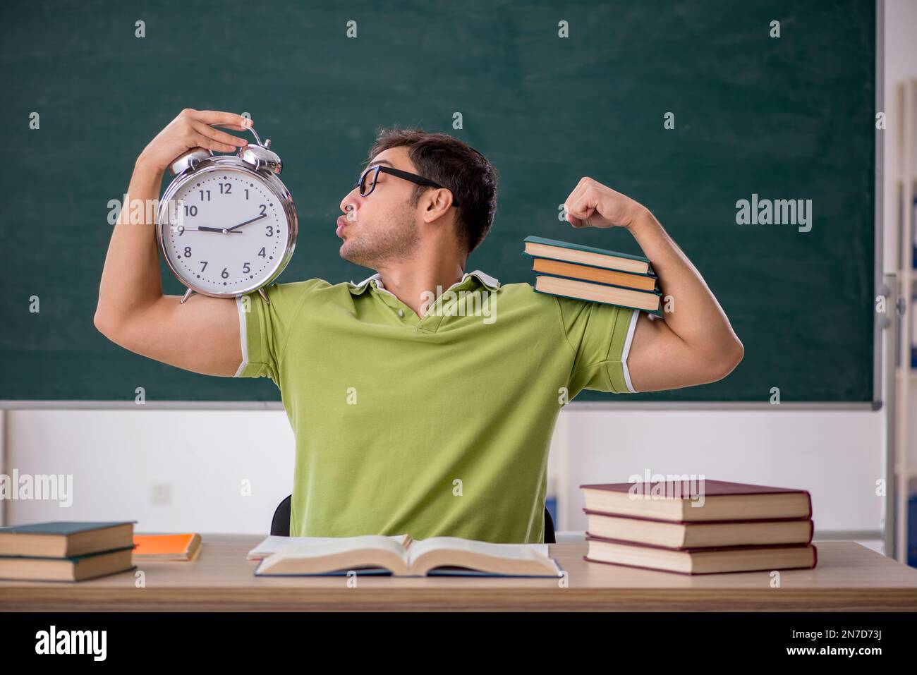 Young student in the classroom in time management concept Stock Photo ...