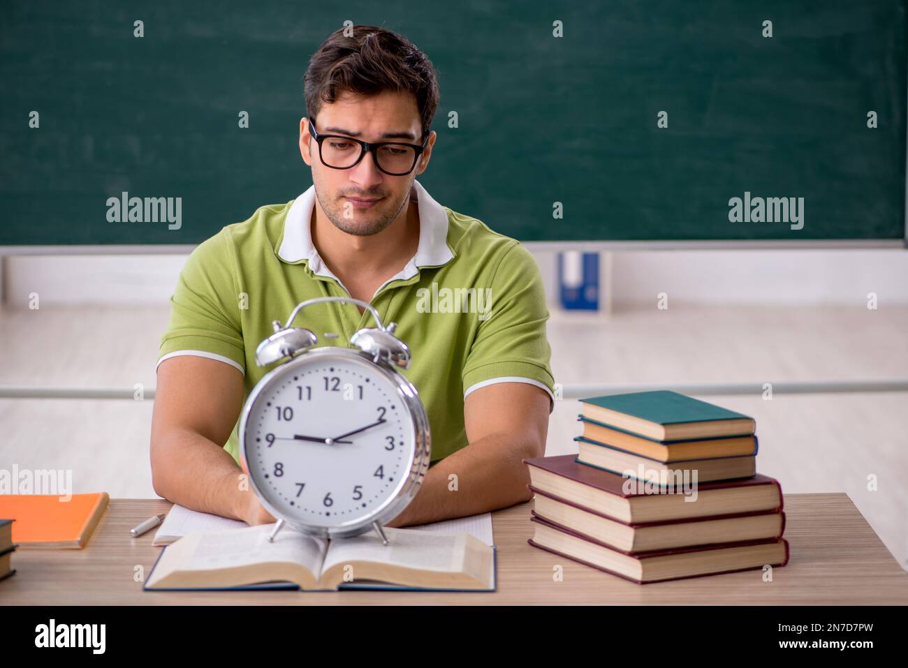 Young student in the classroom in time management concept Stock Photo ...