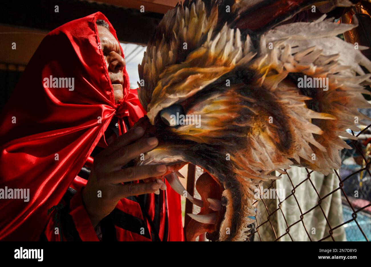 A man holds a traditional devil mask during Corpus Christi celebrations ...
