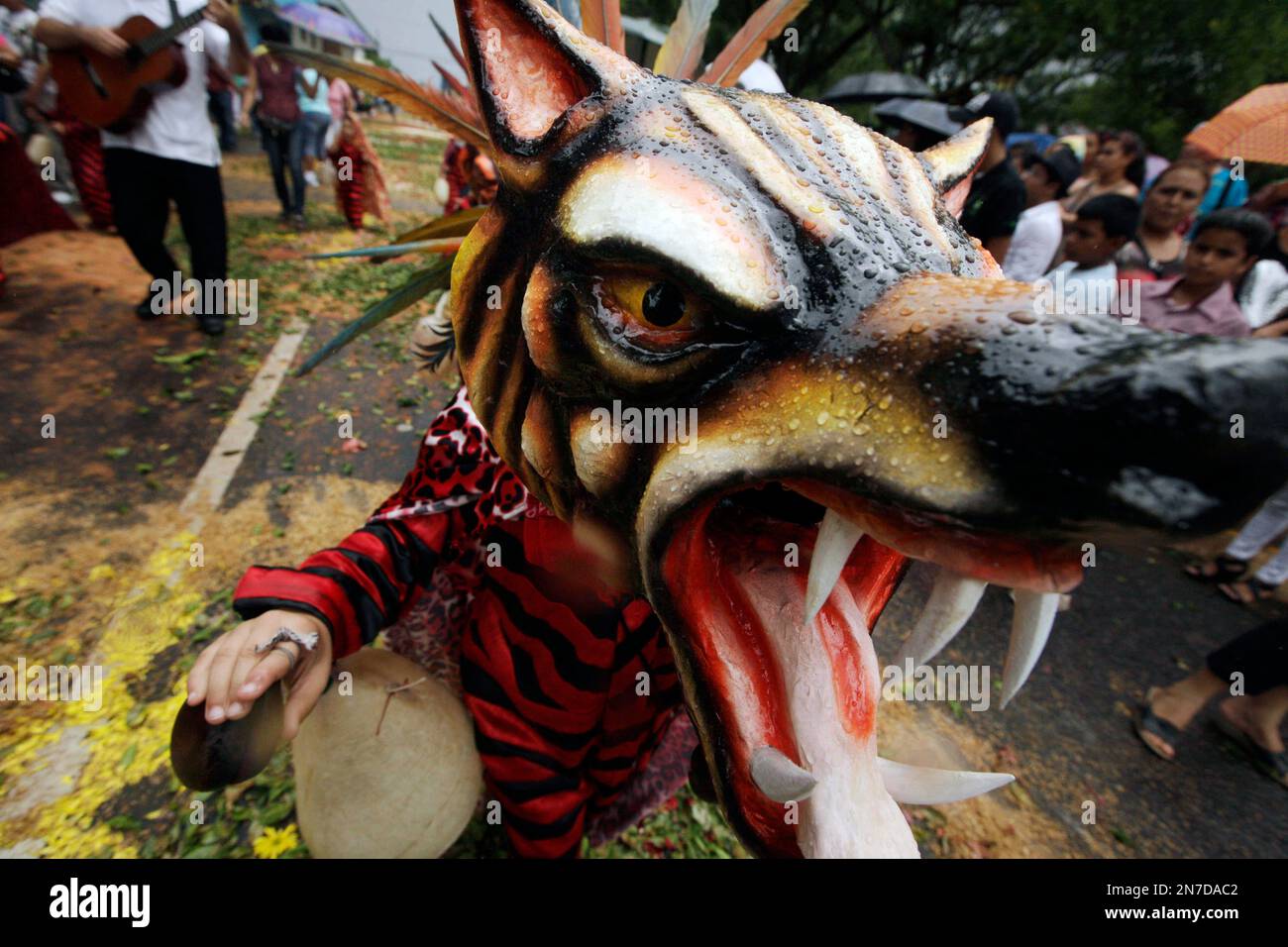A boy wearing a traditional devil mask dances in the streets of La ...