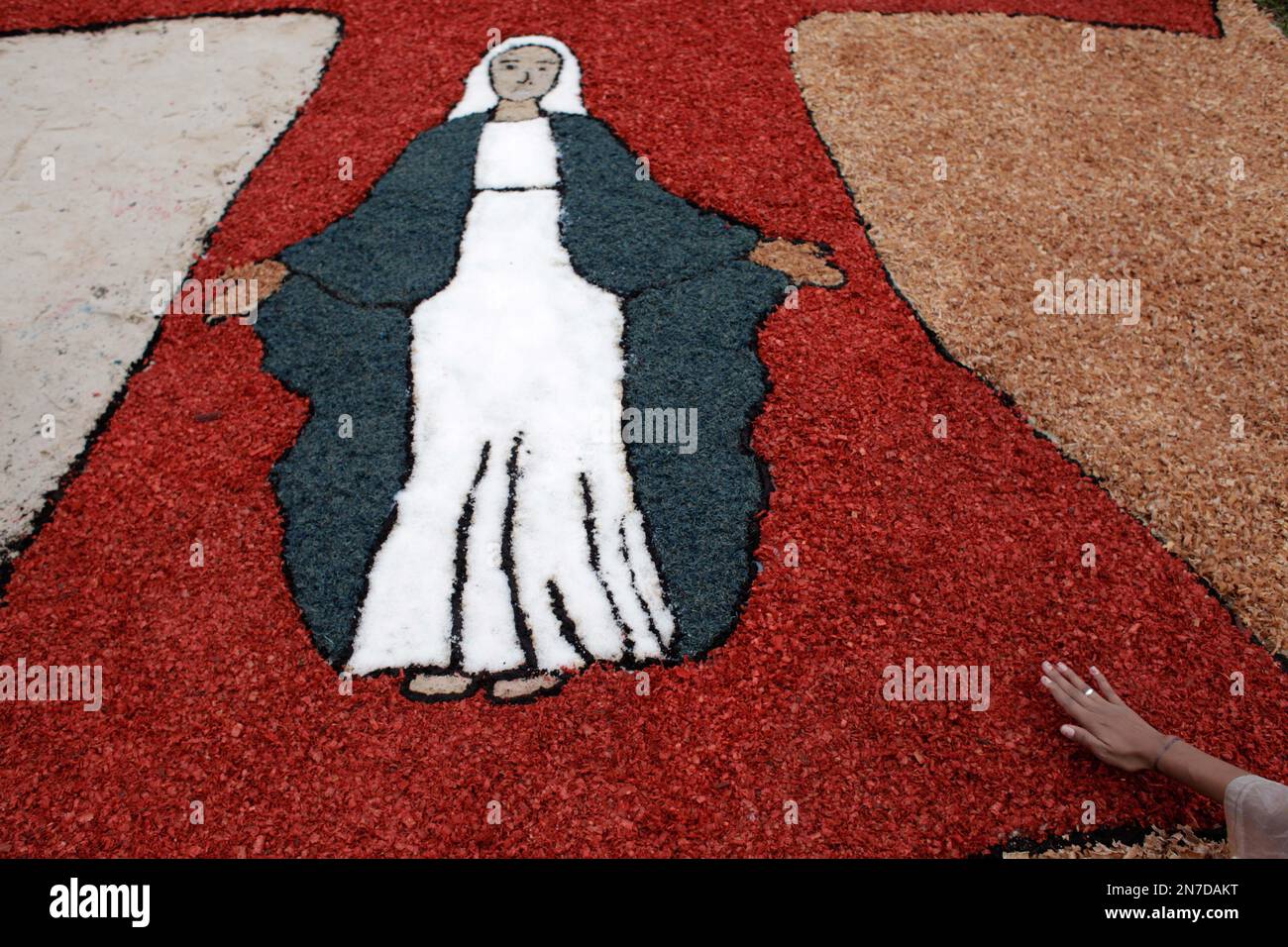 A woman helps to design a traditional sawdust carpet rug that features ...