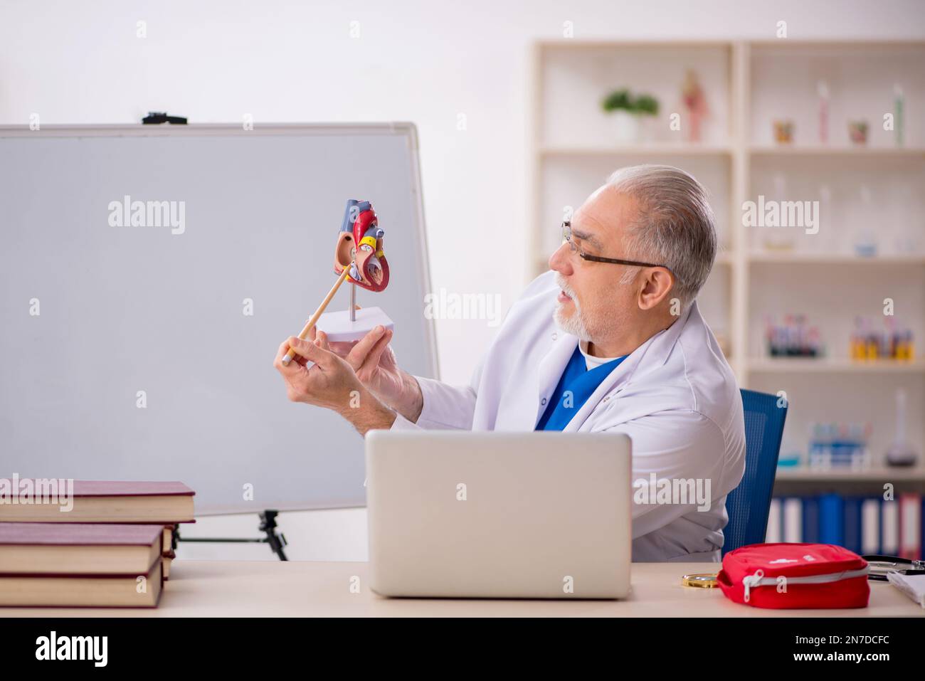 Old doctor cardiologist working at the hospital Stock Photo - Alamy