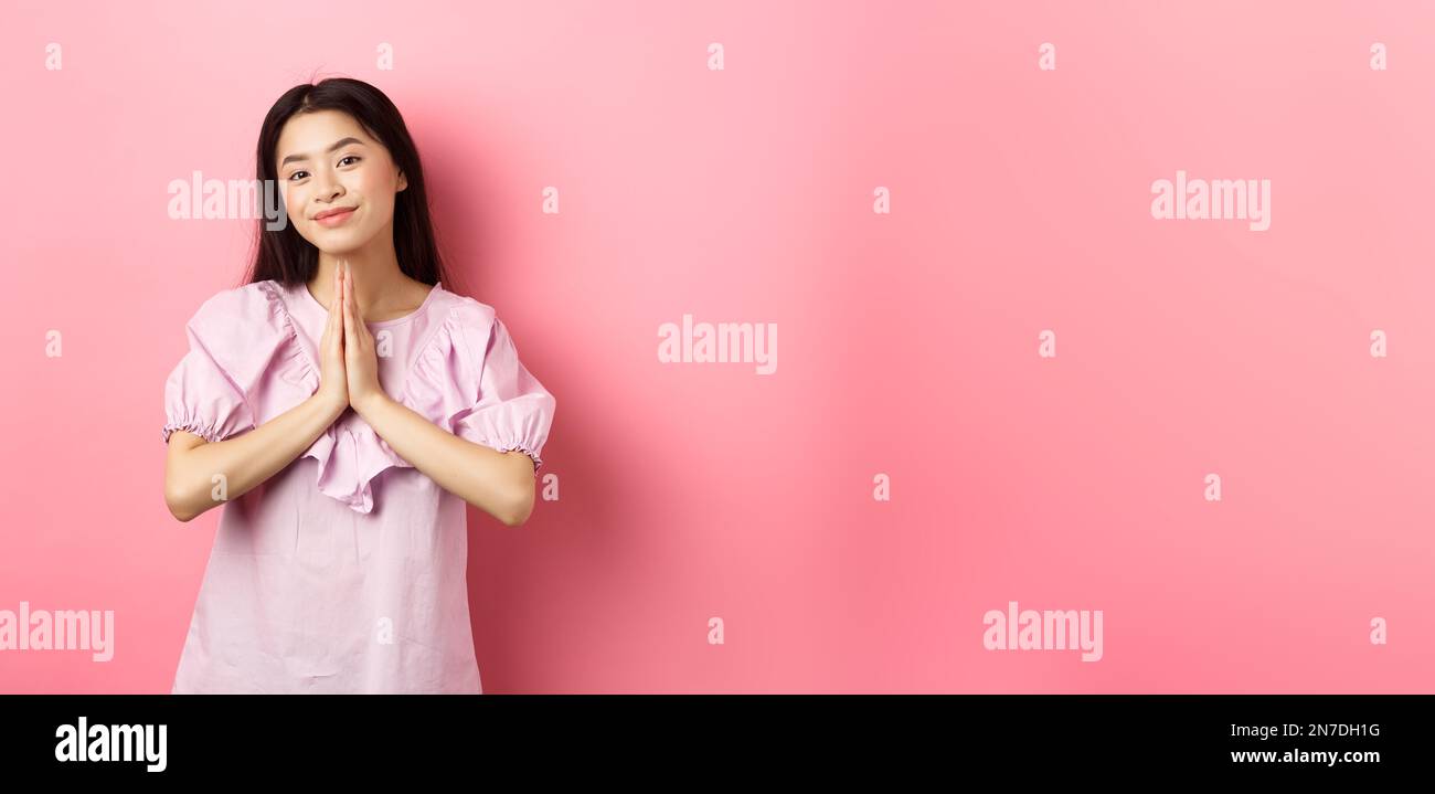 Cute asian girl say thank you, smiling and looking happy, showing ...