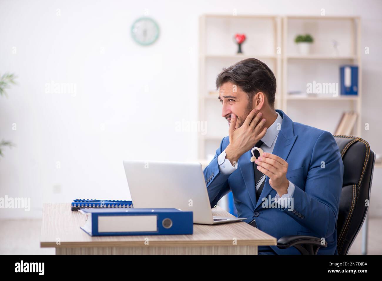 Deaf businessman employee using hearing aid in the office Stock Photo ...