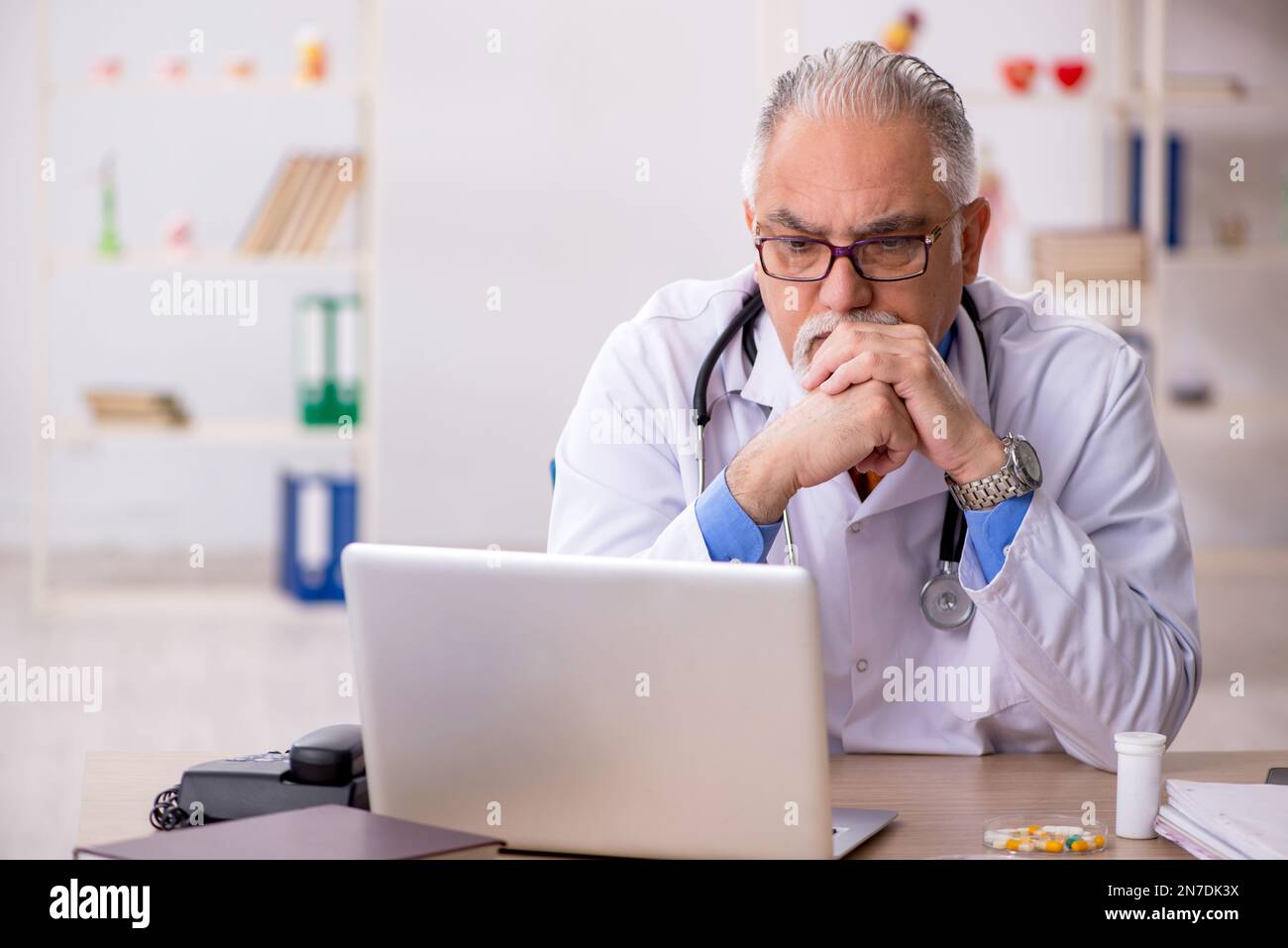 Old doctor working in the clinic Stock Photo - Alamy