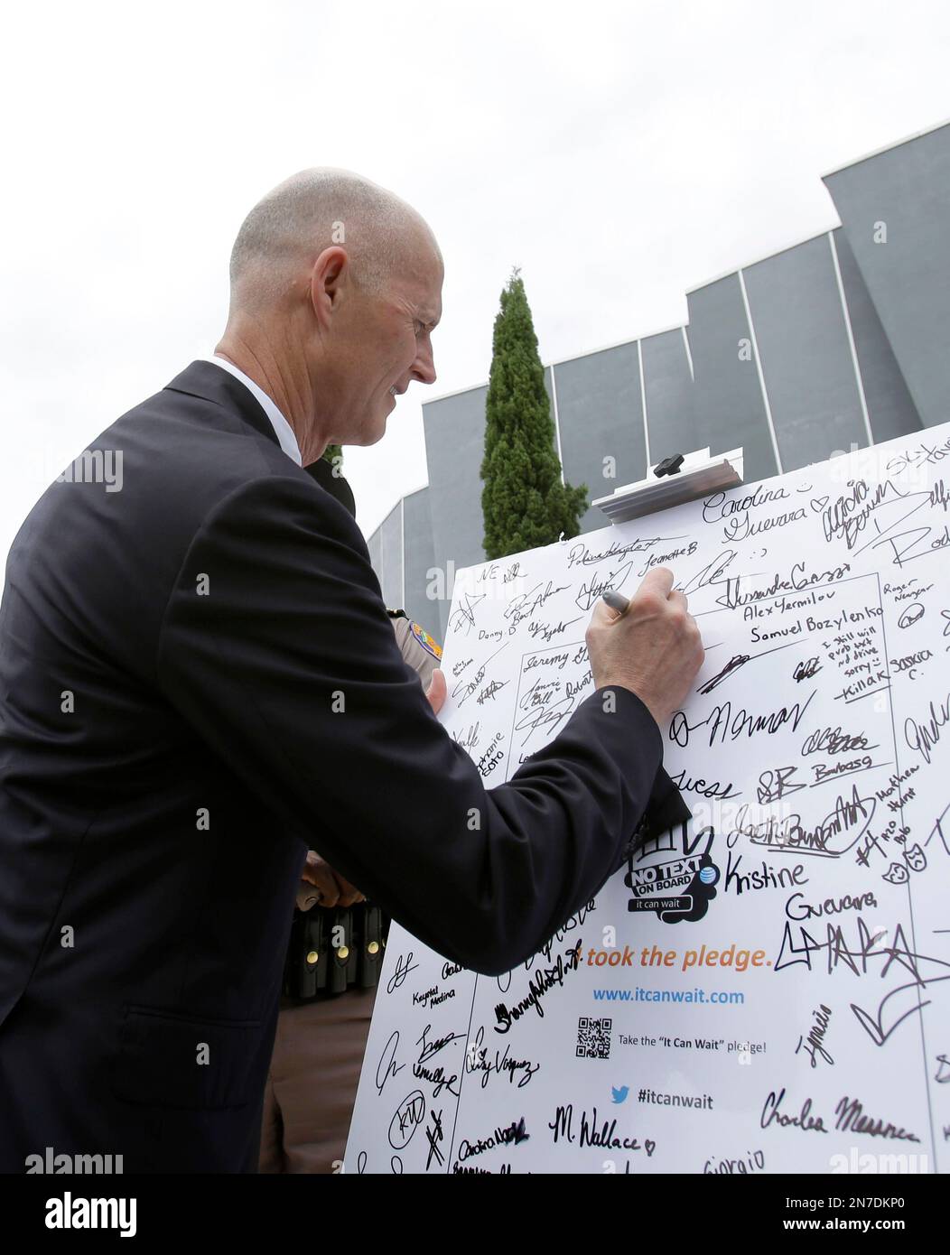 Florida Gov. Rick Scott signs a pledge to not text and drive on a ...