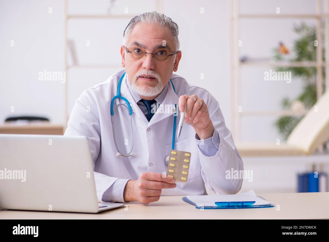Old doctor working in the clinic Stock Photo - Alamy