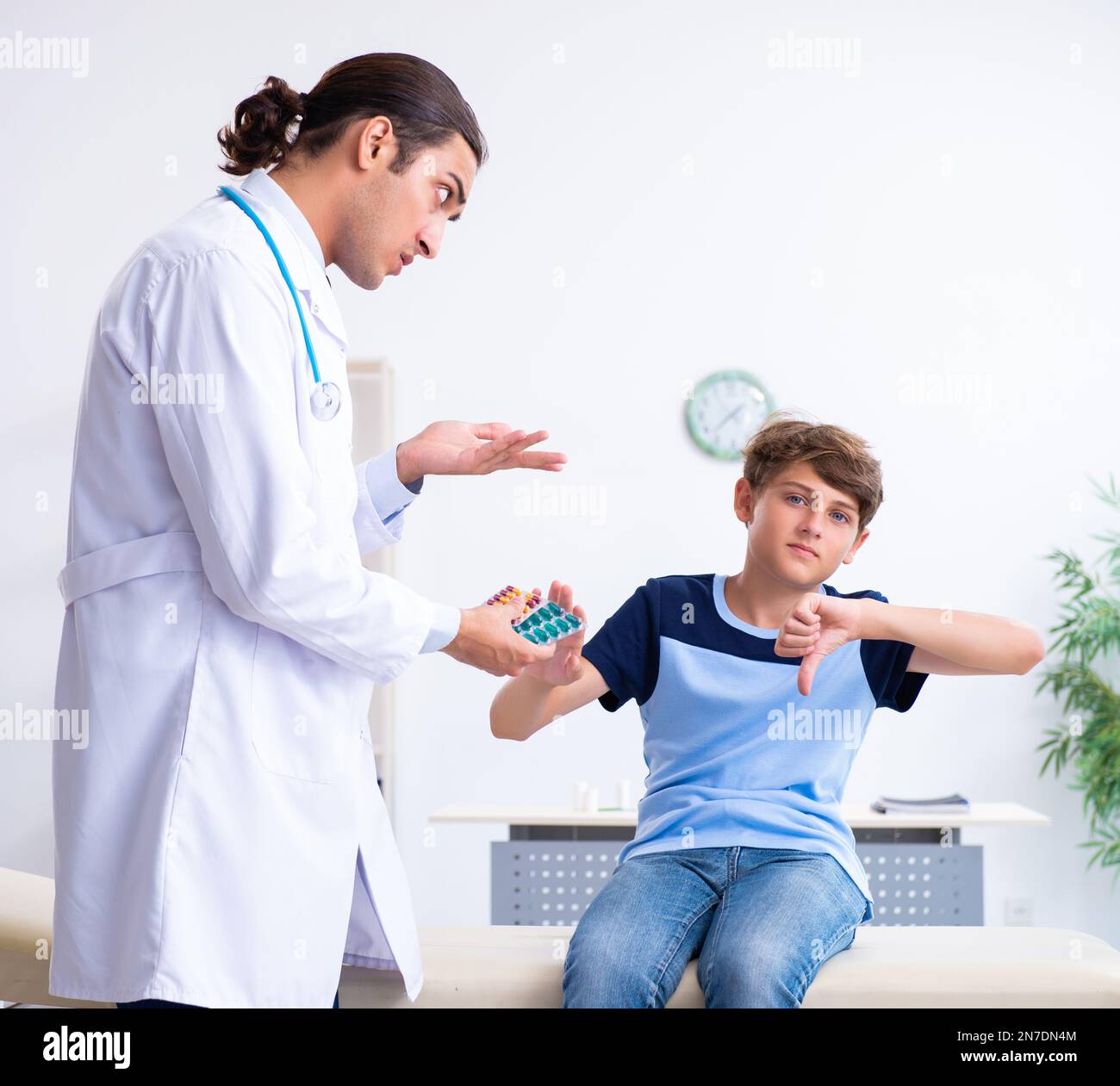 The young male doctor examining boy in the clinic Stock Photo - Alamy