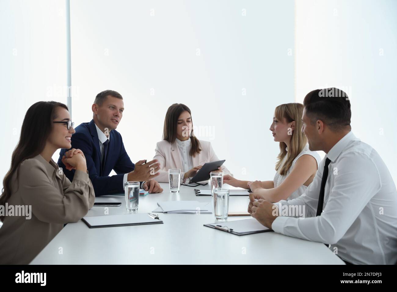 Office employees talking at table during meeting Stock Photo - Alamy
