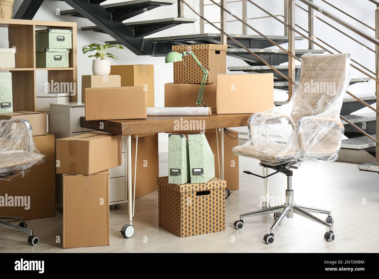 Cardboard boxes and furniture near stairs in office. Moving day Stock ...