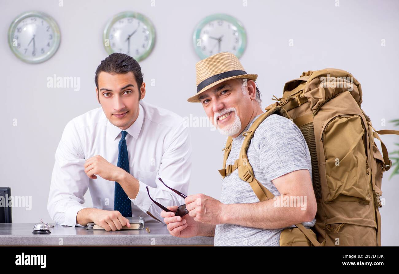 Old backpacker at the hotel reception Stock Photo - Alamy