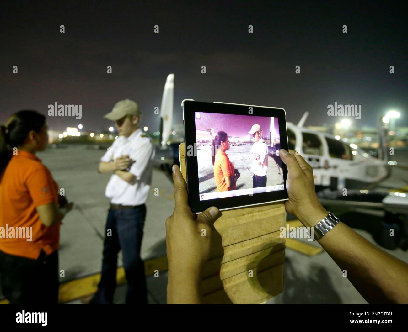 An airport official takes photos of American Jack Wiegand, from Fresno ...