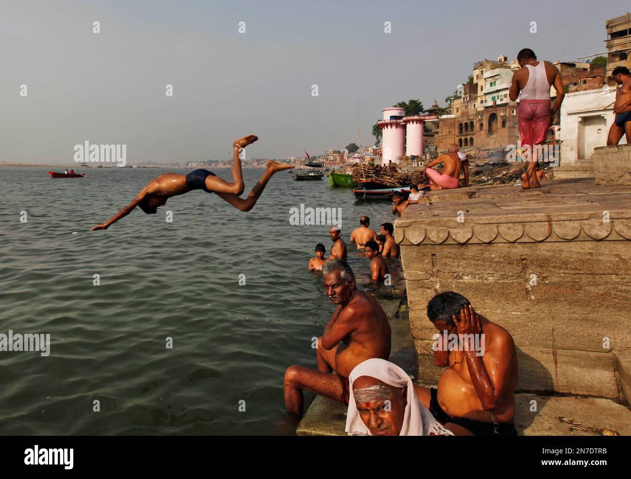 An Indian boy jumps into the River Ganges to beat the heat in Varanasi ...