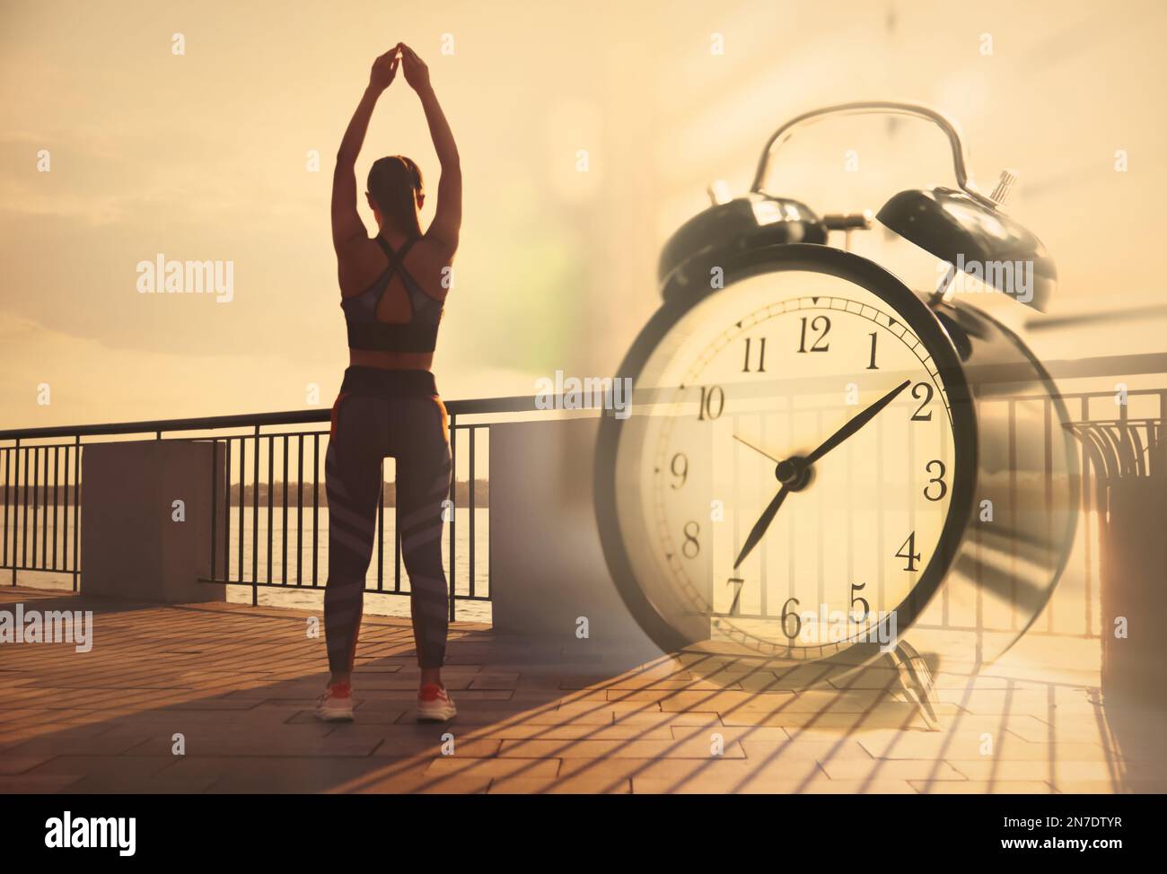 Workout time. Double exposure of woman doing exercise on sunny morning ...
