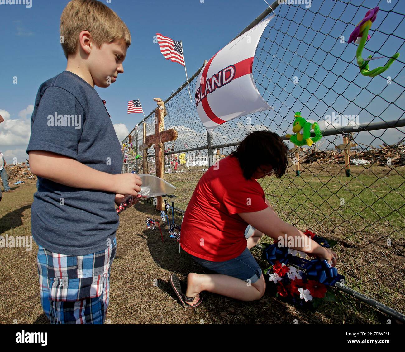 Ethan Crellin, 8, watches his mother lays a wreath at a makeshift ...