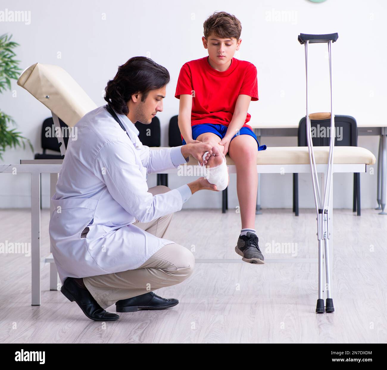 The leg injured boy visiting young doctor traumatologist Stock Photo ...
