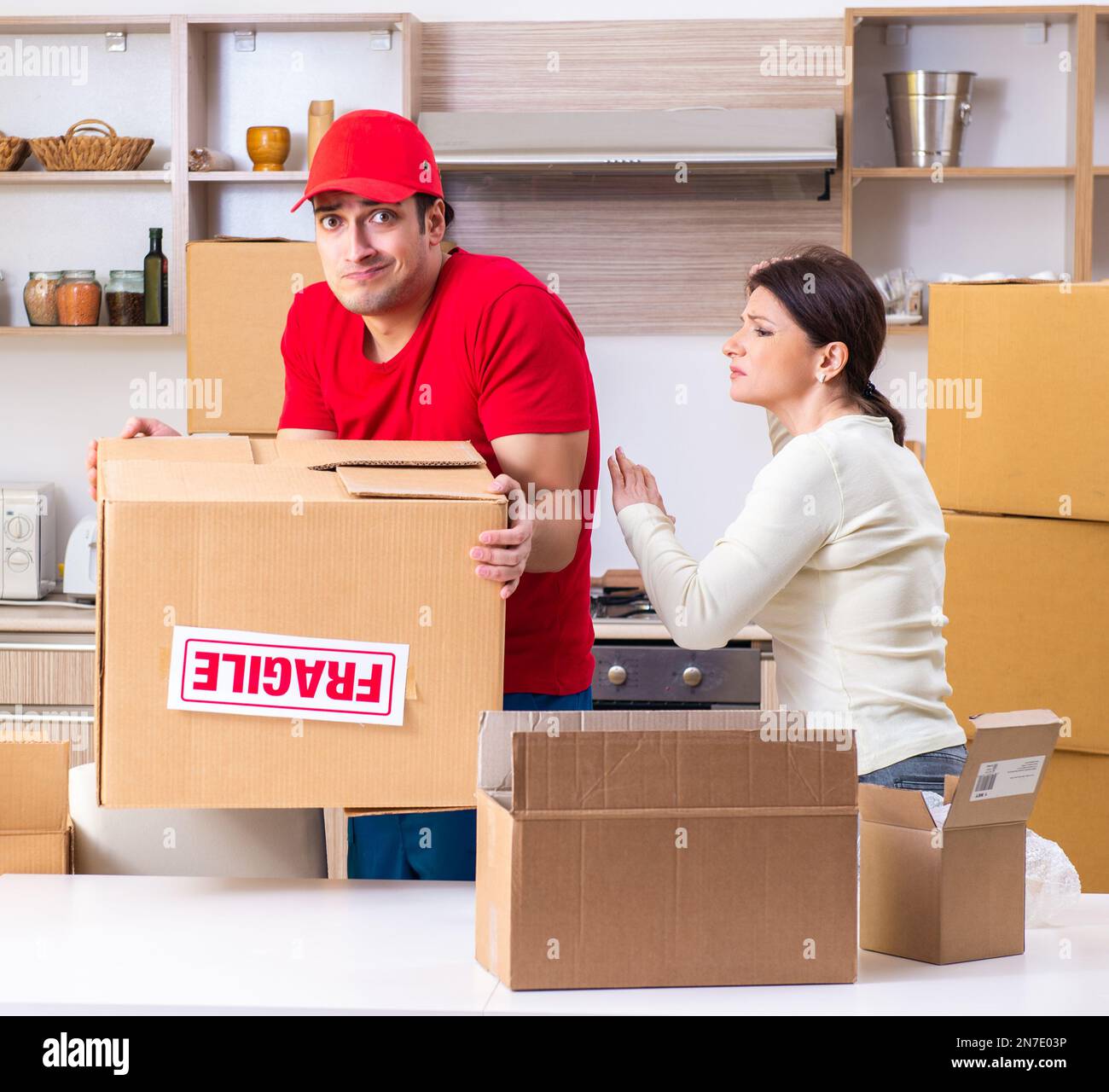 The young male contractor and female customer in moving concept Stock ...