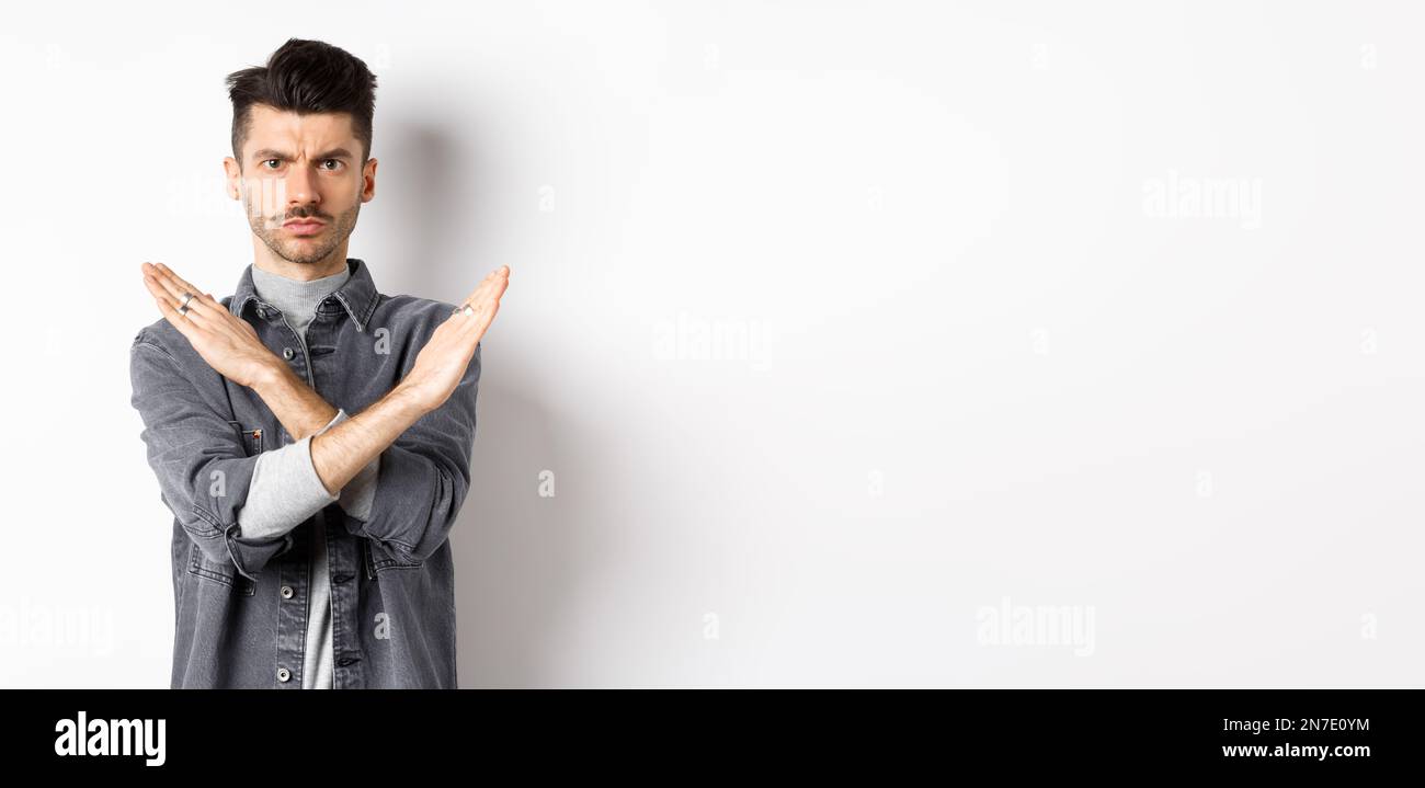 Angry man show cross gesture to stop or say no, frowning and looking ...