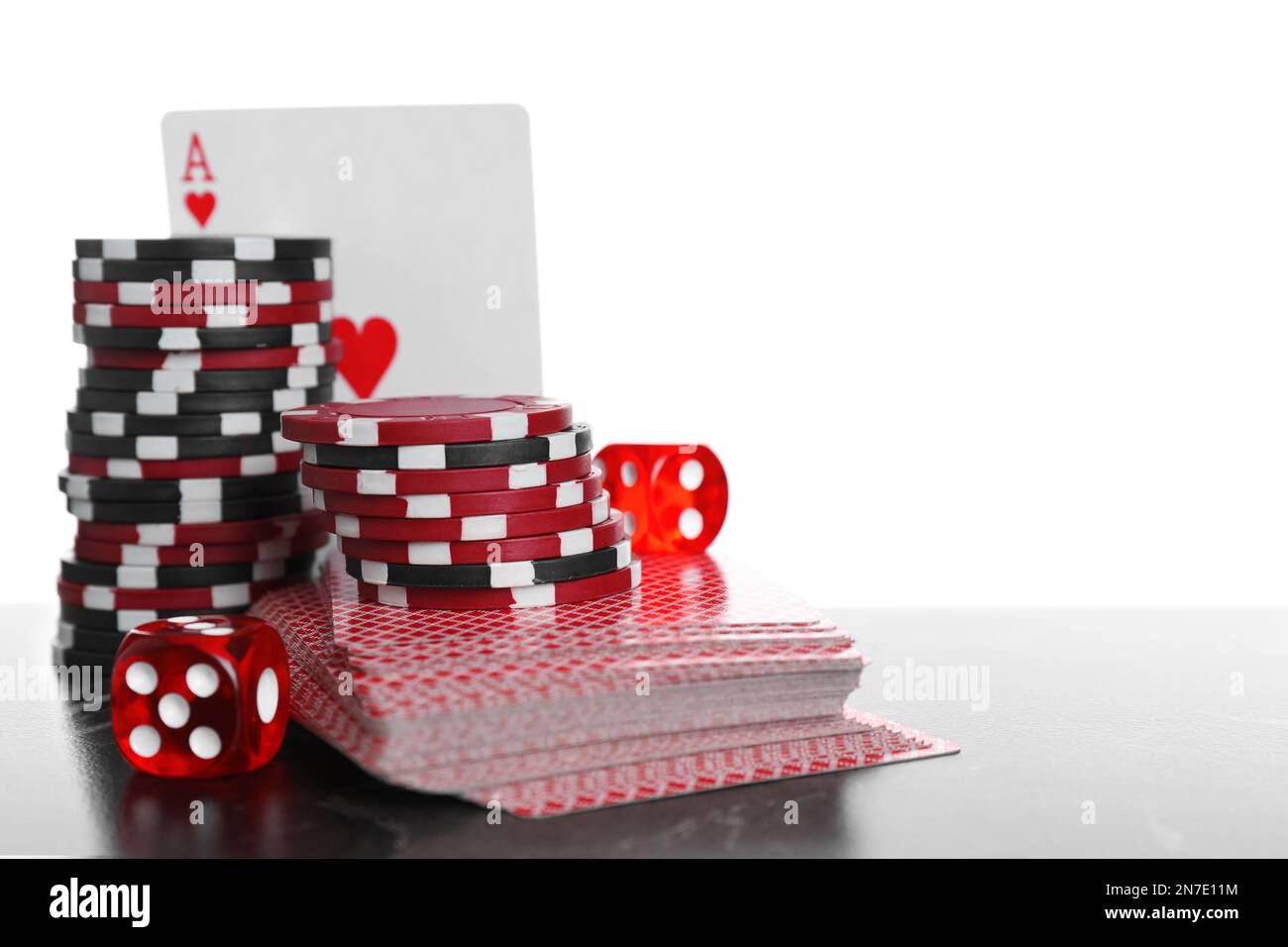 Gaming chips, dice and cards on table against white background Stock ...