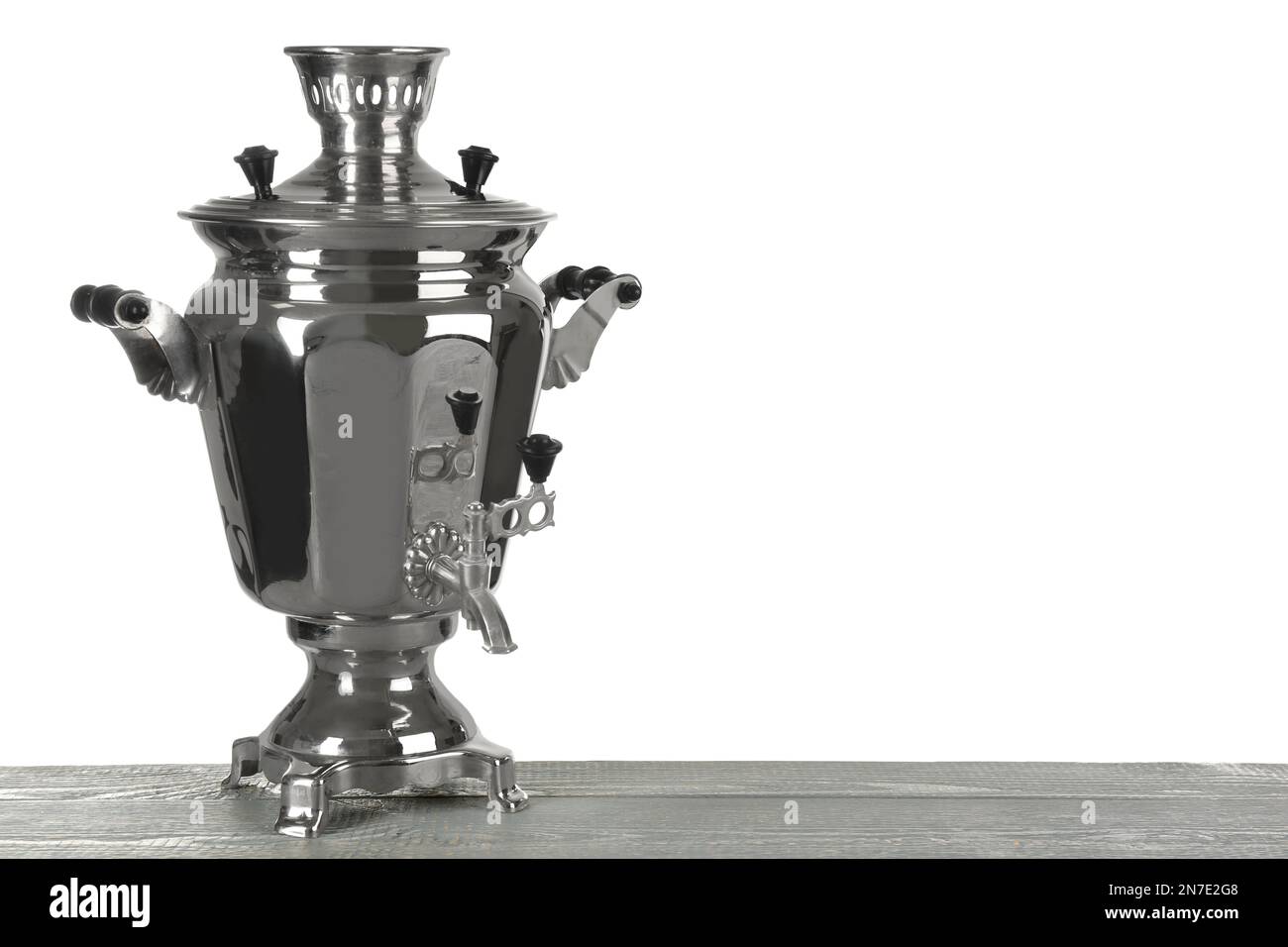 Traditional Russian samovar on wooden table against white background ...