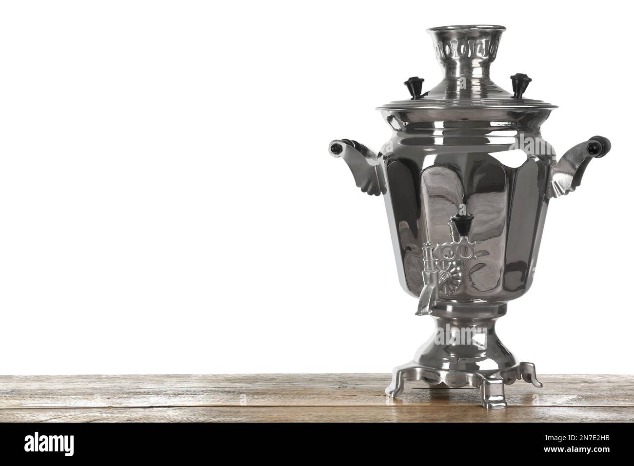 Traditional Russian samovar on wooden table against white background ...
