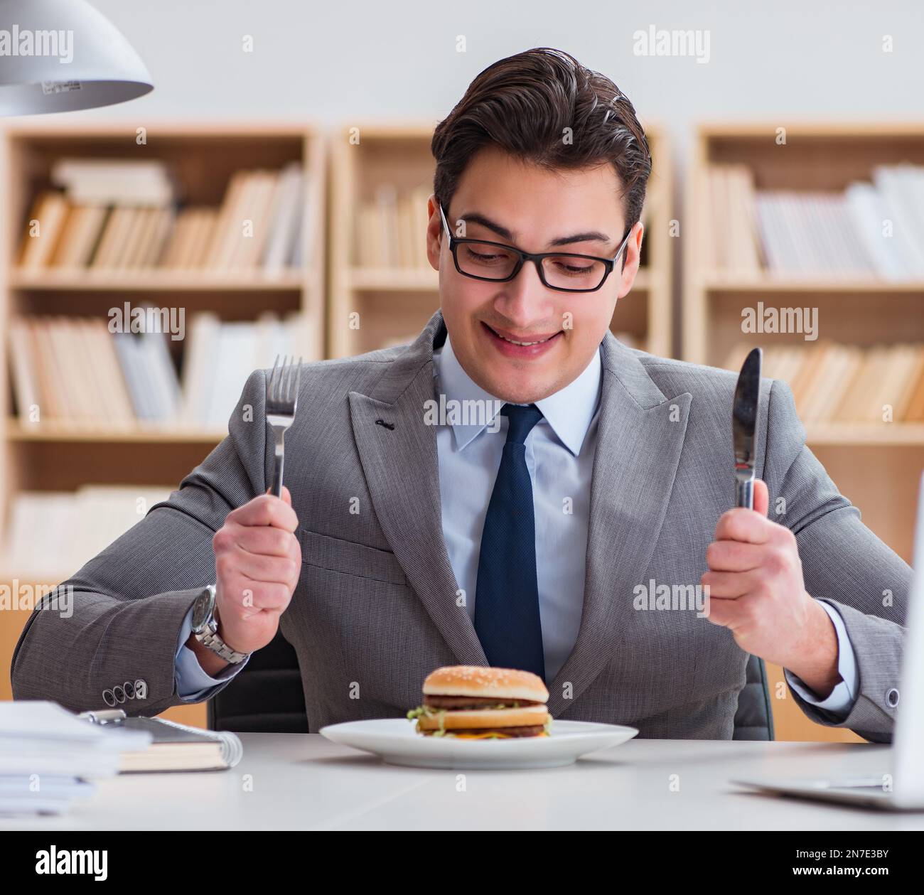 The hungry funny businessman eating junk food sandwich Stock Photo - Alamy