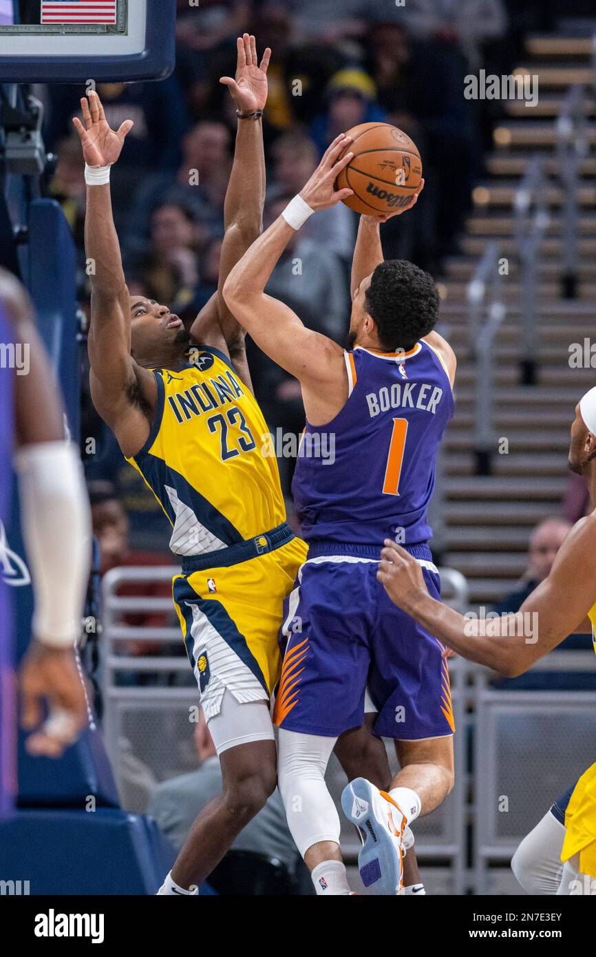 Phoenix Suns guard Devin Booker (1) shoots while being defended by Indiana Pacers forward Aaron ...