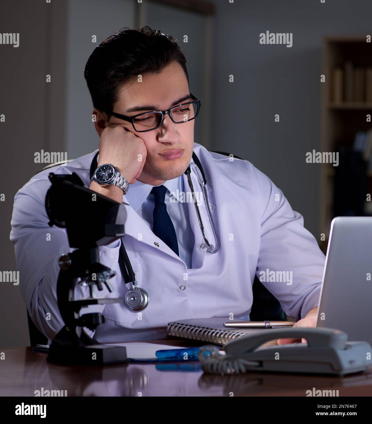 The young doctor working late in the office Stock Photo - Alamy
