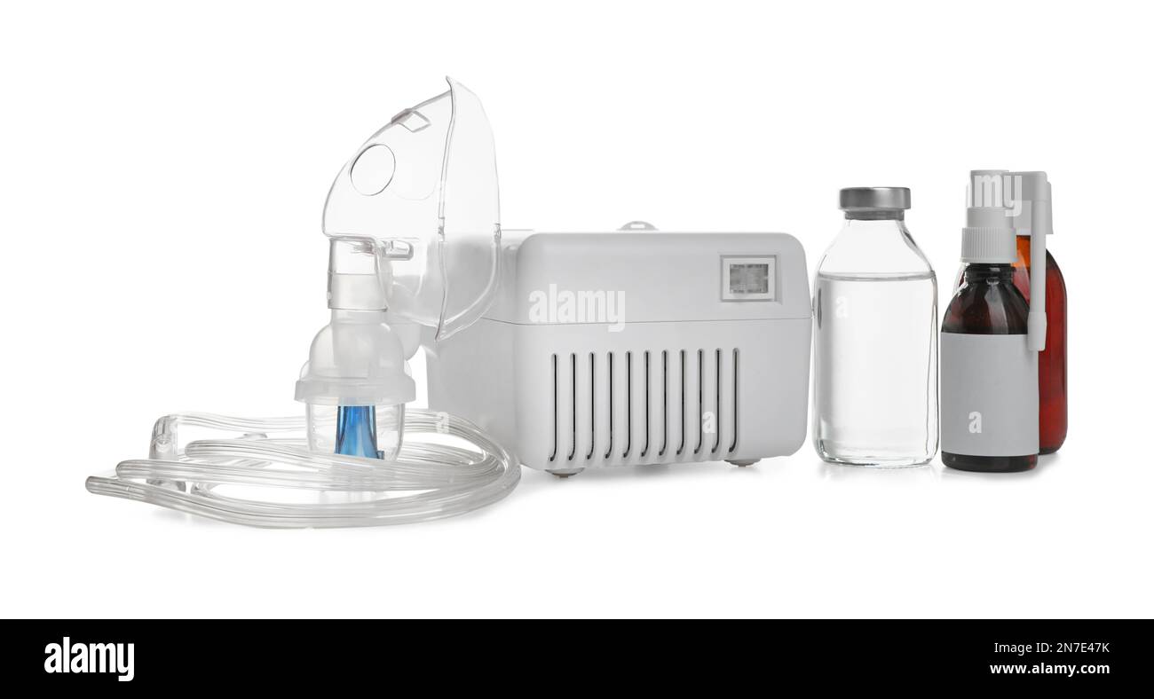 Modern nebulizer with face mask and medications on white background ...