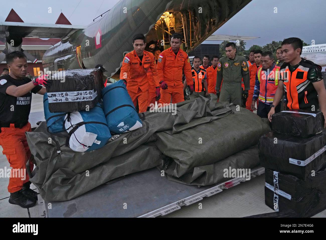 Rescue workers and military personnel load relief goods which will be ...