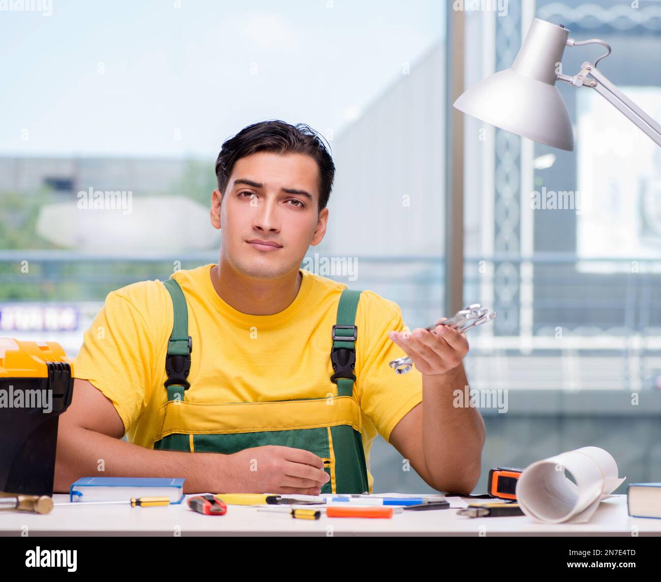 The construction worker sitting at the desk Stock Photo - Alamy