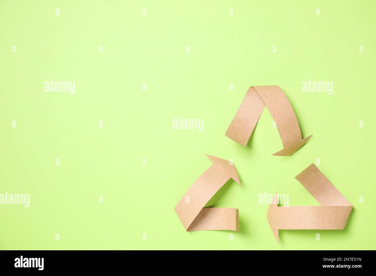 Recycling symbol cut out of paper on green background, top view. Space ...