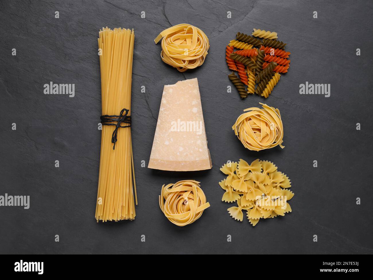 Different types of pasta and cheese on black table, flat lay Stock ...