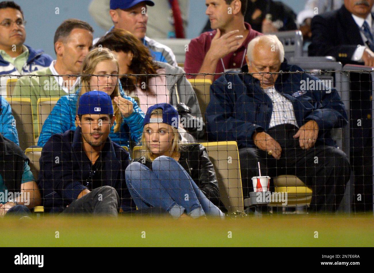 Actor Taylor Lautner, left and Sara Hicks, center, watch the Los ...