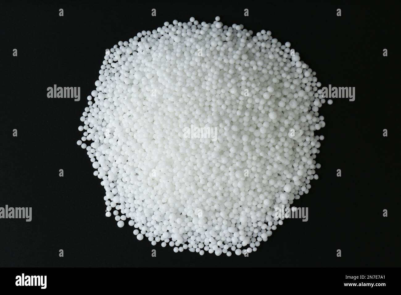 Pellets of ammonium nitrate on black background, flat lay. Mineral ...