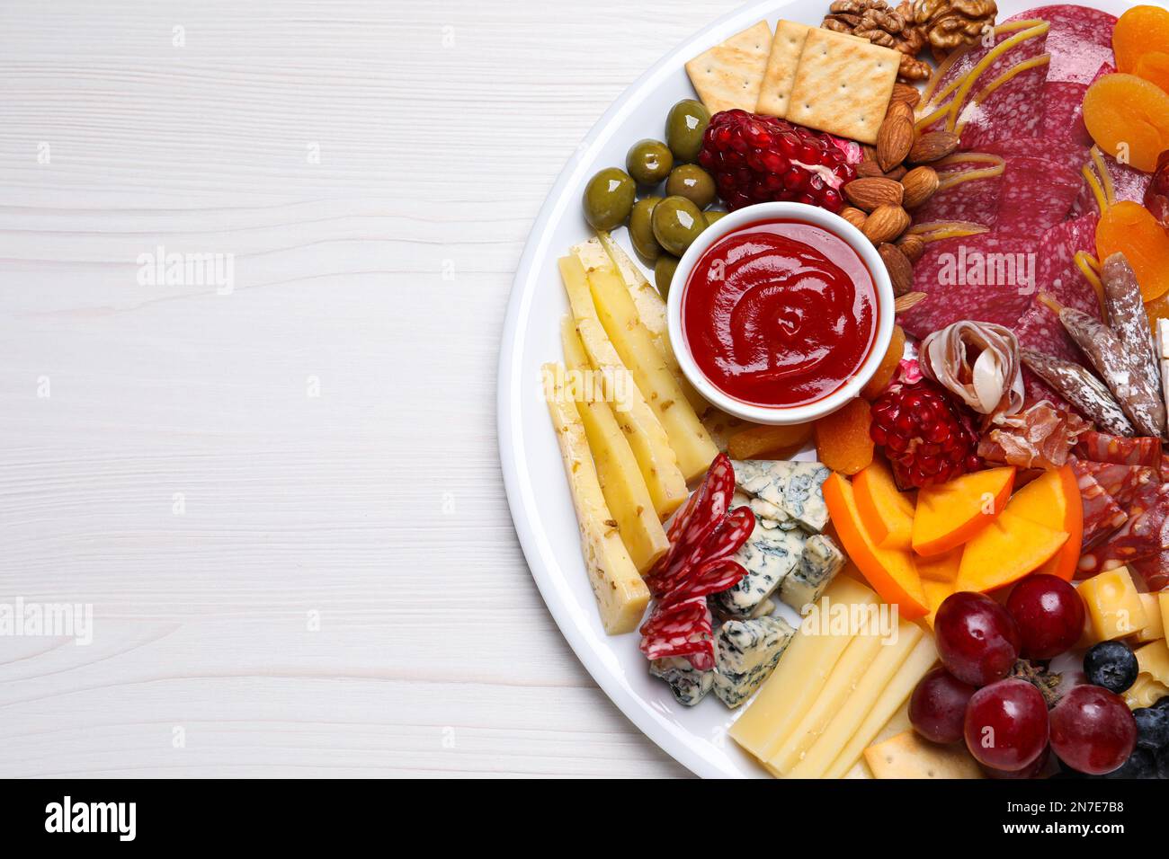 Plate of different appetizers with sauce on white wooden table, top ...