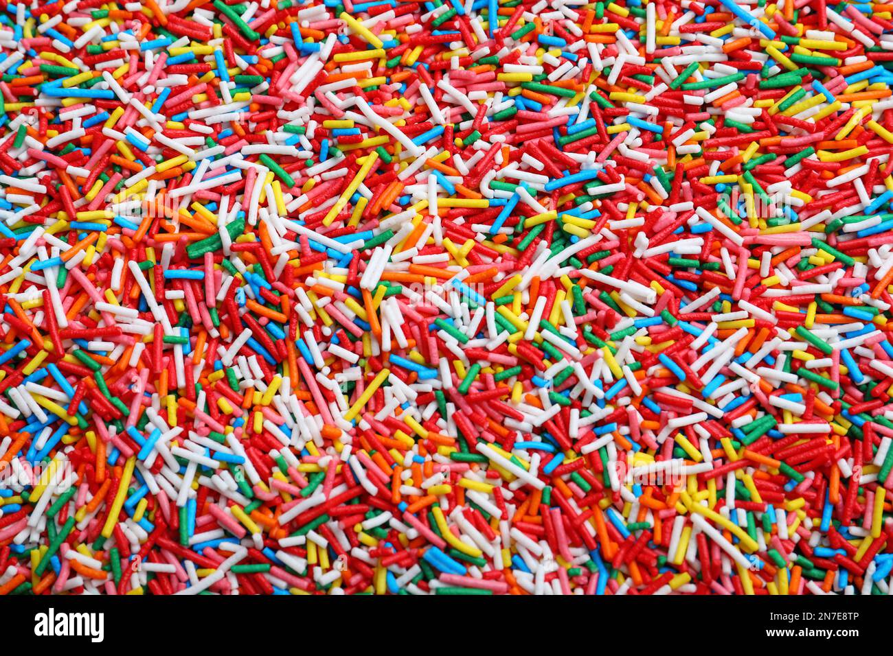 Bright colorful sprinkles as background, top view. Confectionery decor ...