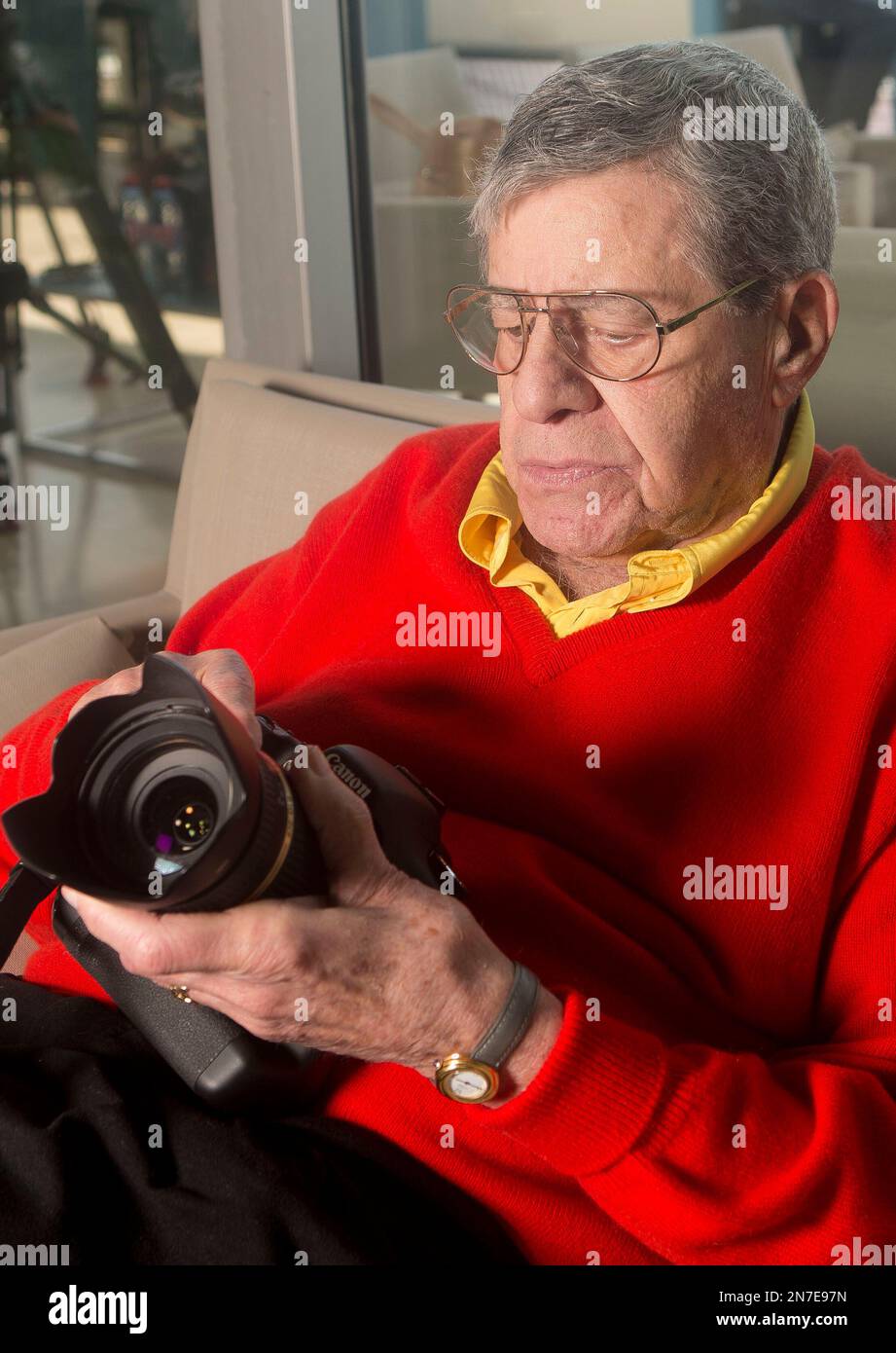 Comedian Jerry Lewis checks his own camera as he poses for portraits at ...