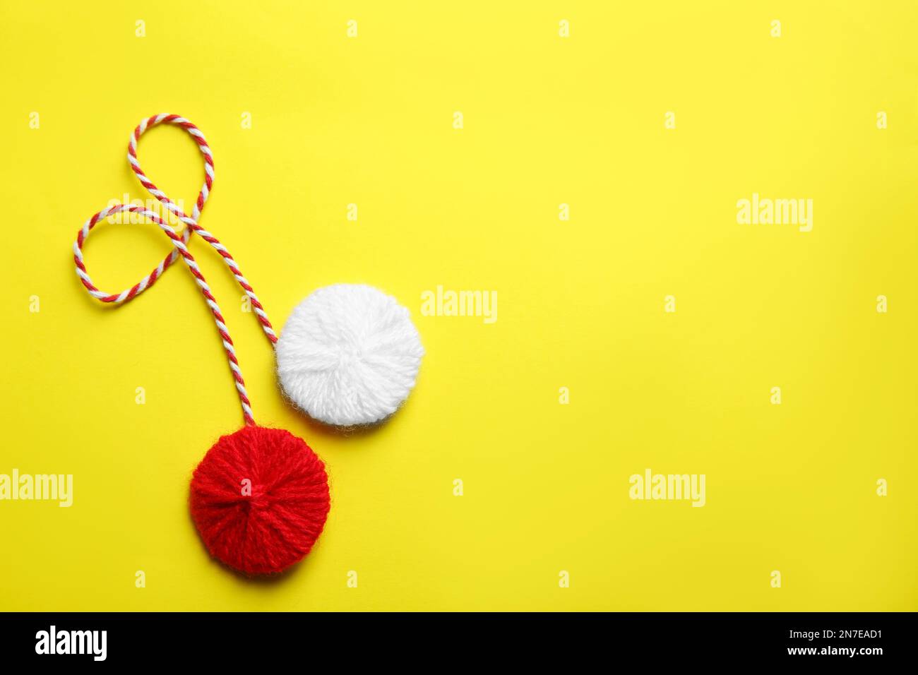 Traditional martisor on yellow background, top view with space for text ...