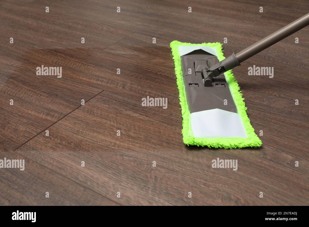 Cleaning of wooden floor with modern mop Stock Photo - Alamy
