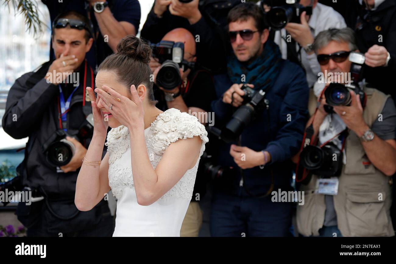 Actress Marion Cotillard rubs her eyes as she poses for photographers ...