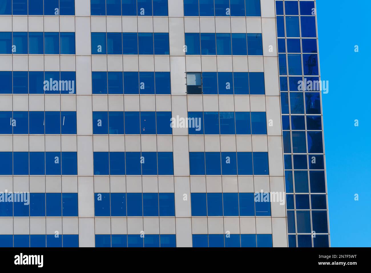 Office building day time view showing blue glass window patterns and ...