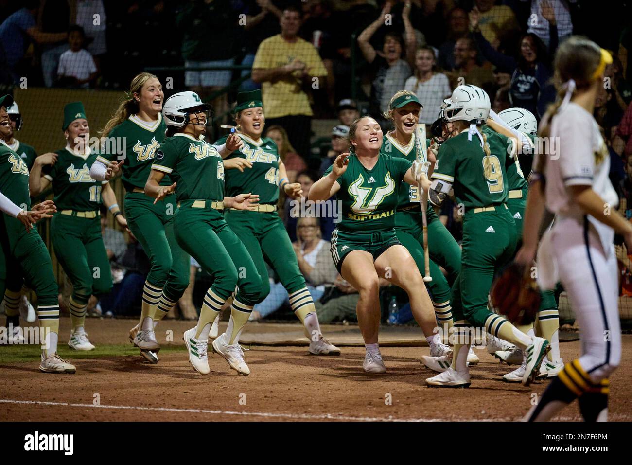 USF Bulls mob Hallie Bryant (2) after scoring the winning run on a wild ...