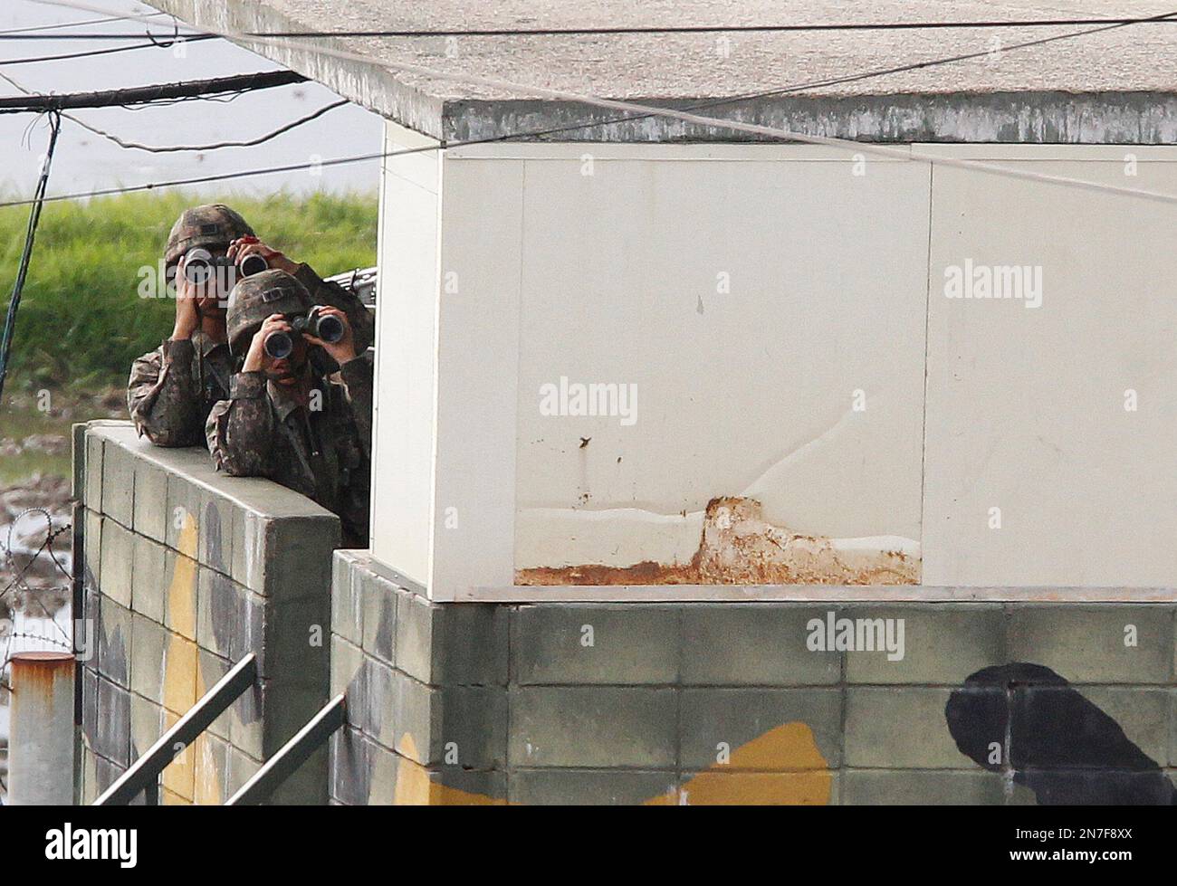 South Korean army soldiers look through telescopes at a military check ...