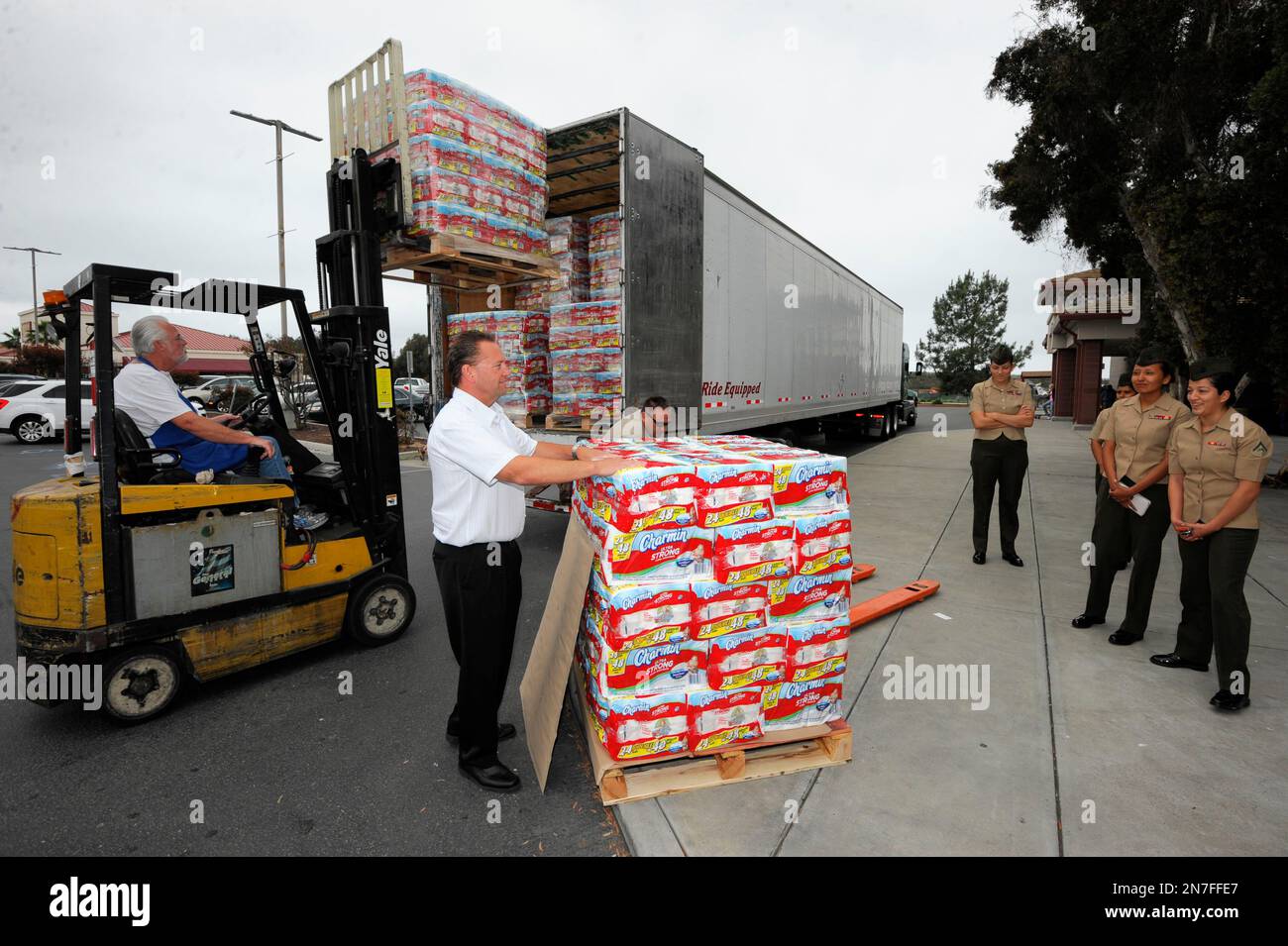 Scott Hill, Camp Pendleton Commissary Director, center, distributes a ...