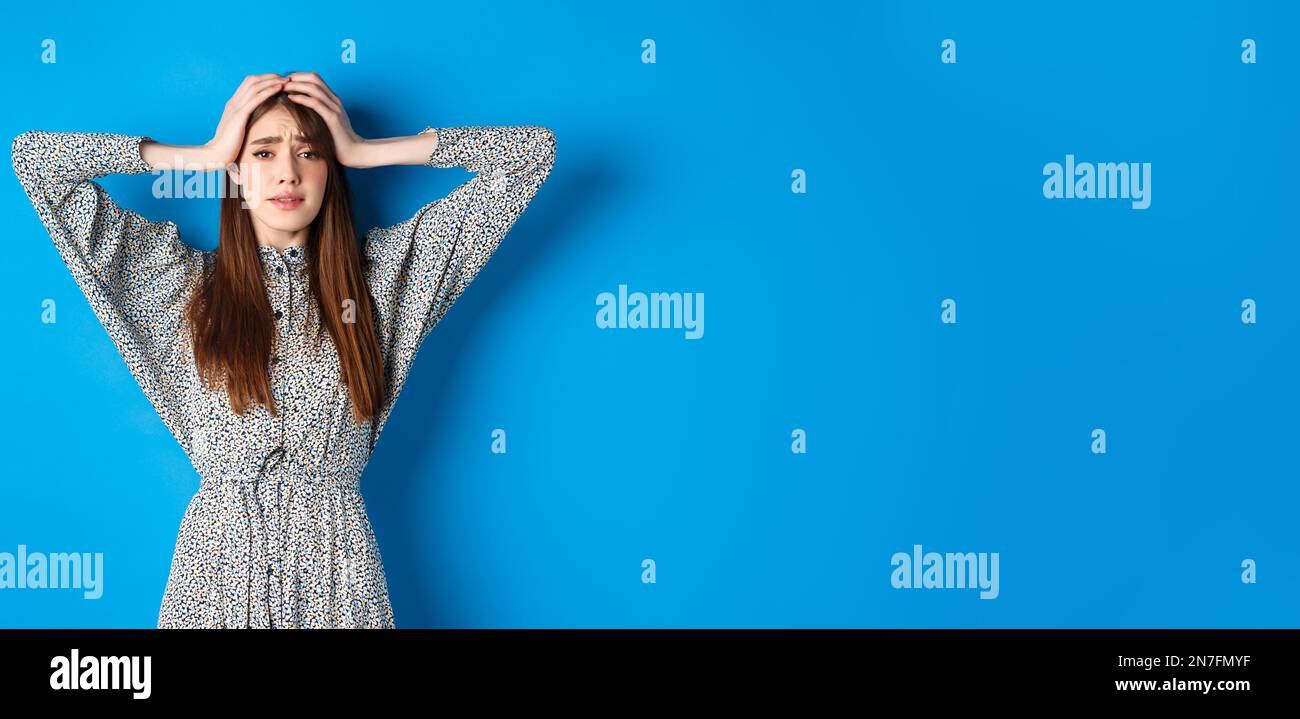 Frustrated adult woman with natural hair holding hands on head and ...