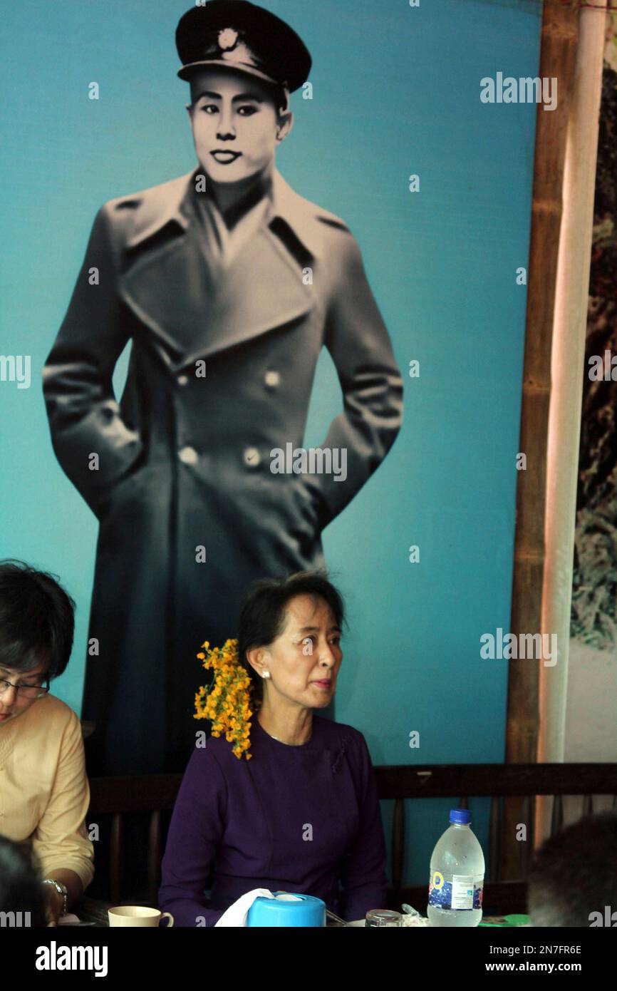 Myanmar opposition leader Aung San Suu Kyi sits under a portrait of her ...