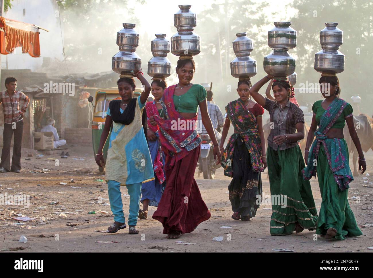 Indian village girls carry water in pitchers on their heads at Juval ...