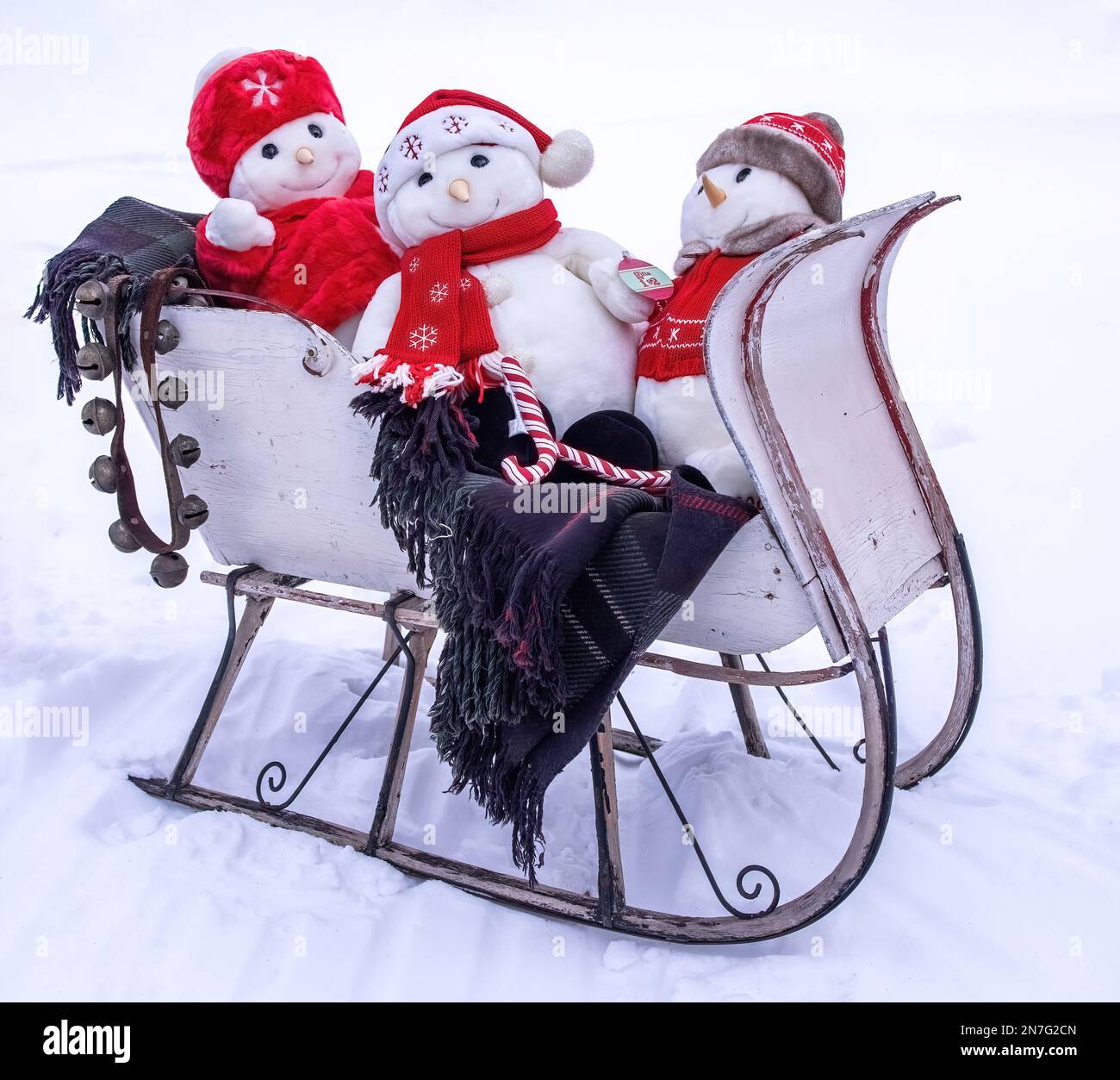 Vintage sleigh with three stuffed snowmen inside and sleighbells on ...