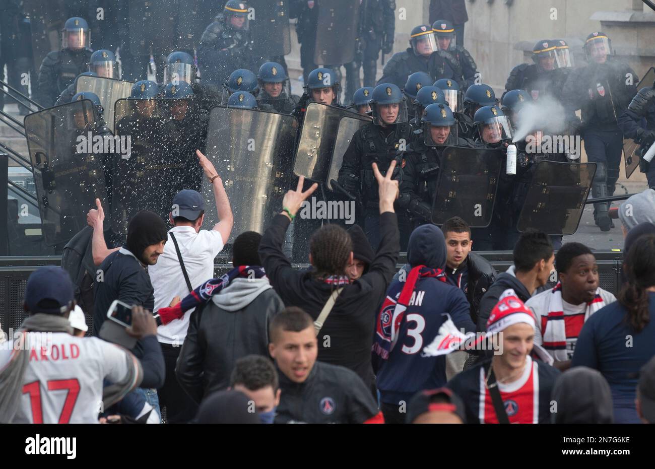 Supporters take cover from teargas, fired by riot police during the ...